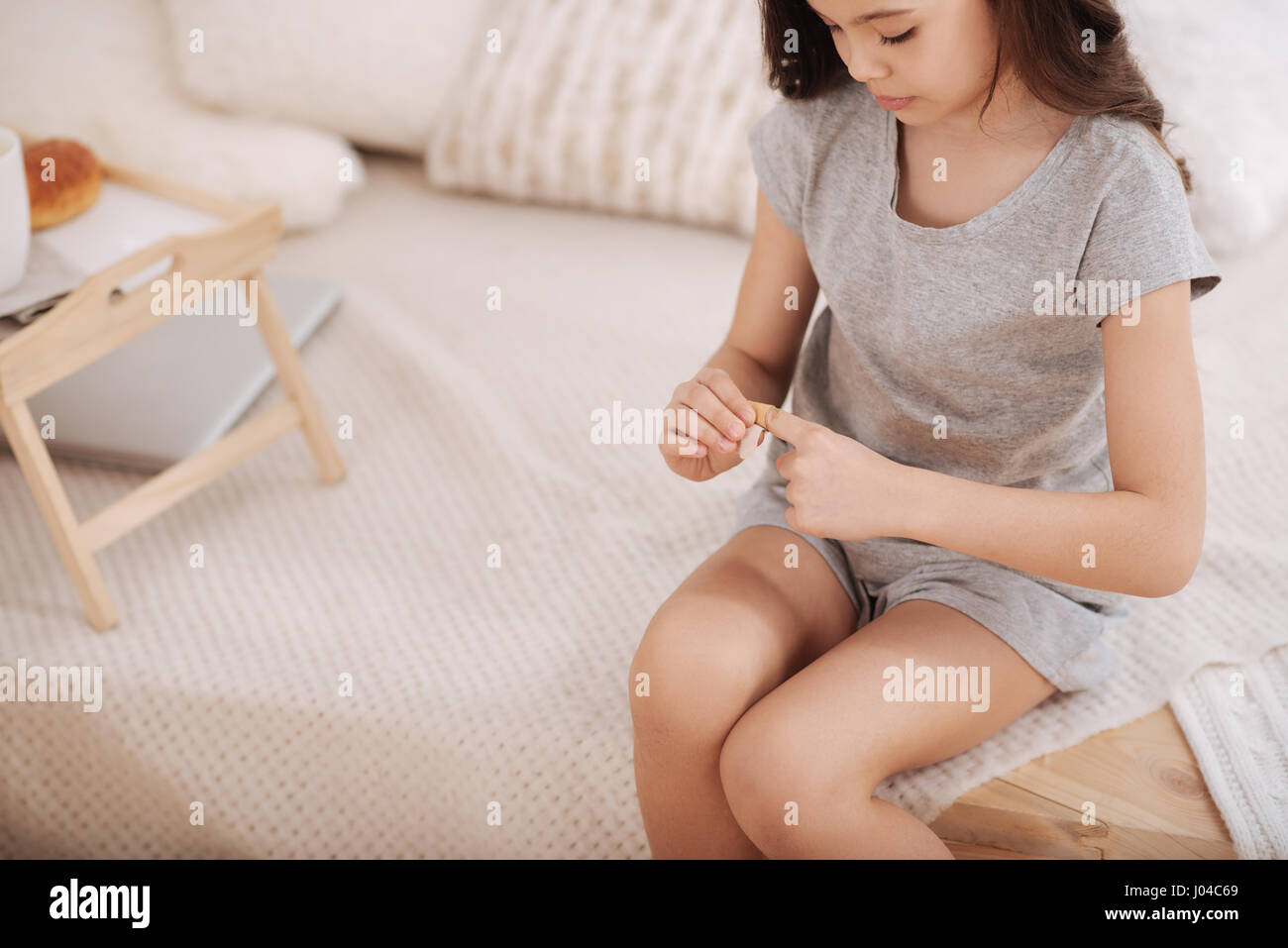 Confident child putting medical patch on the finger at home Stock Photo ...