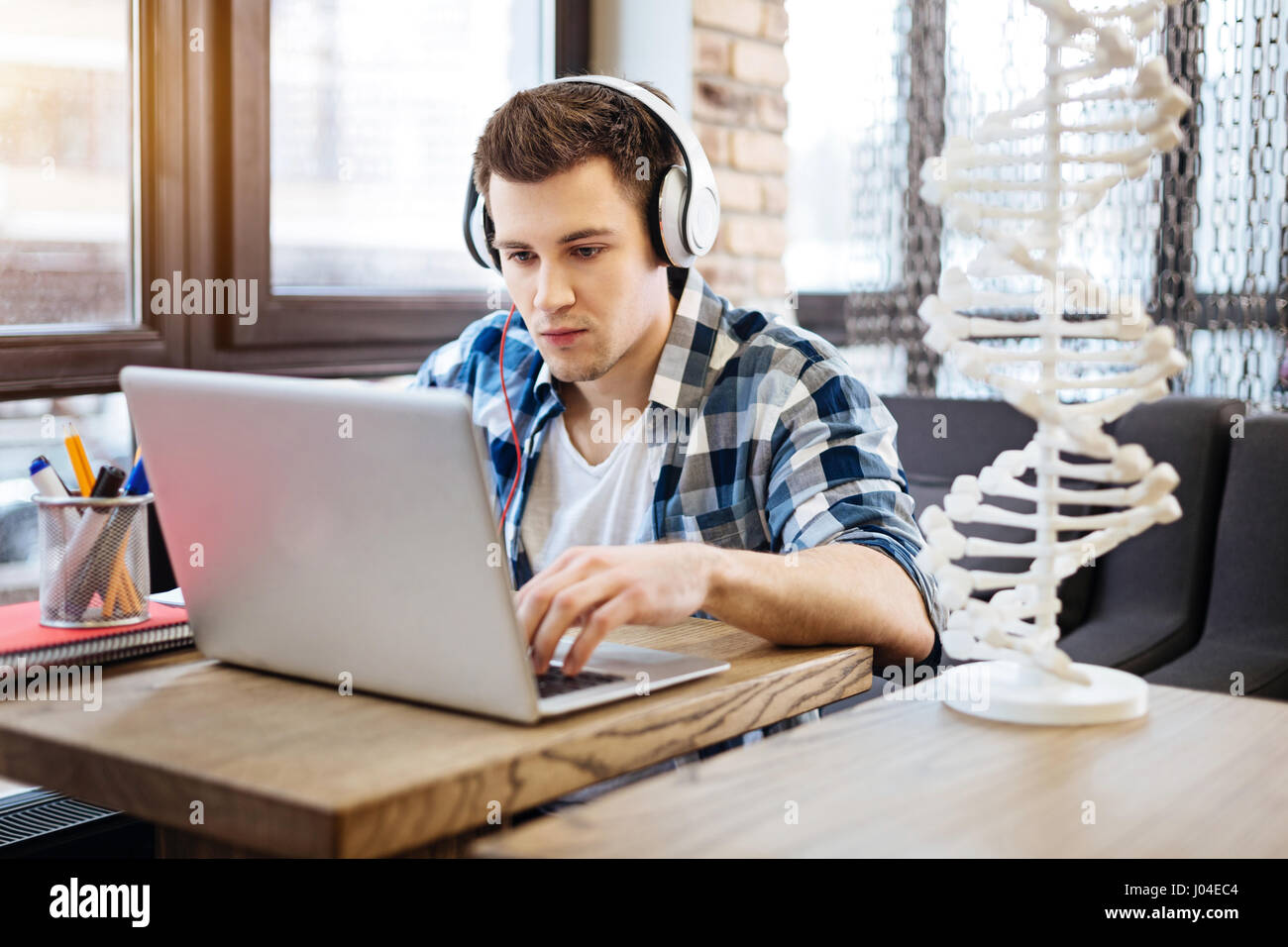 Concentrated young man using laptop Stock Photo - Alamy