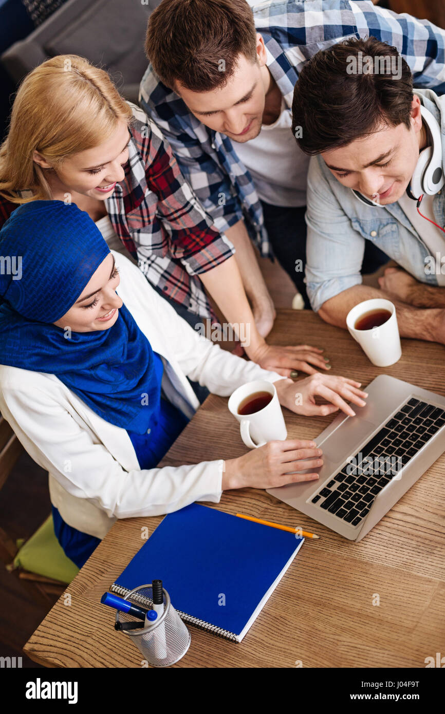 Positive smiling international students sitting in the cafe Stock Photo ...