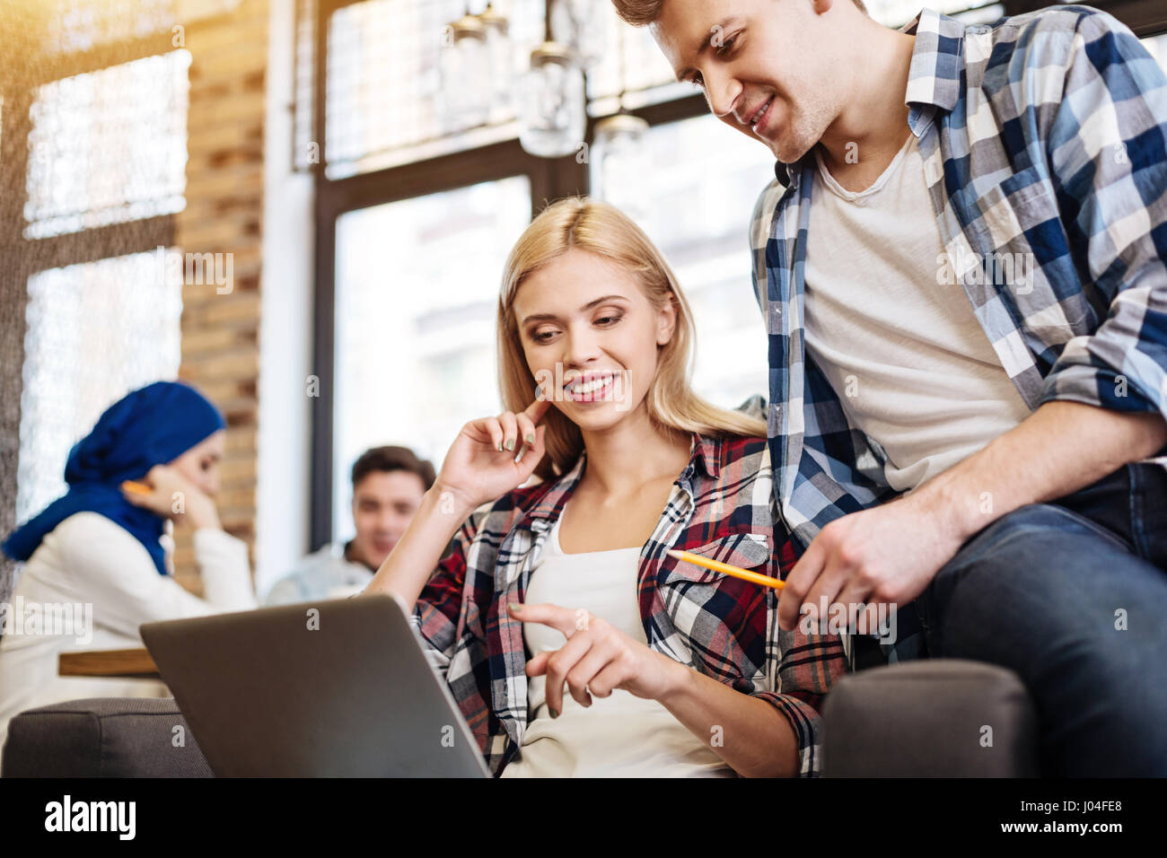 Smiling young students discussing project work Stock Photo - Alamy
