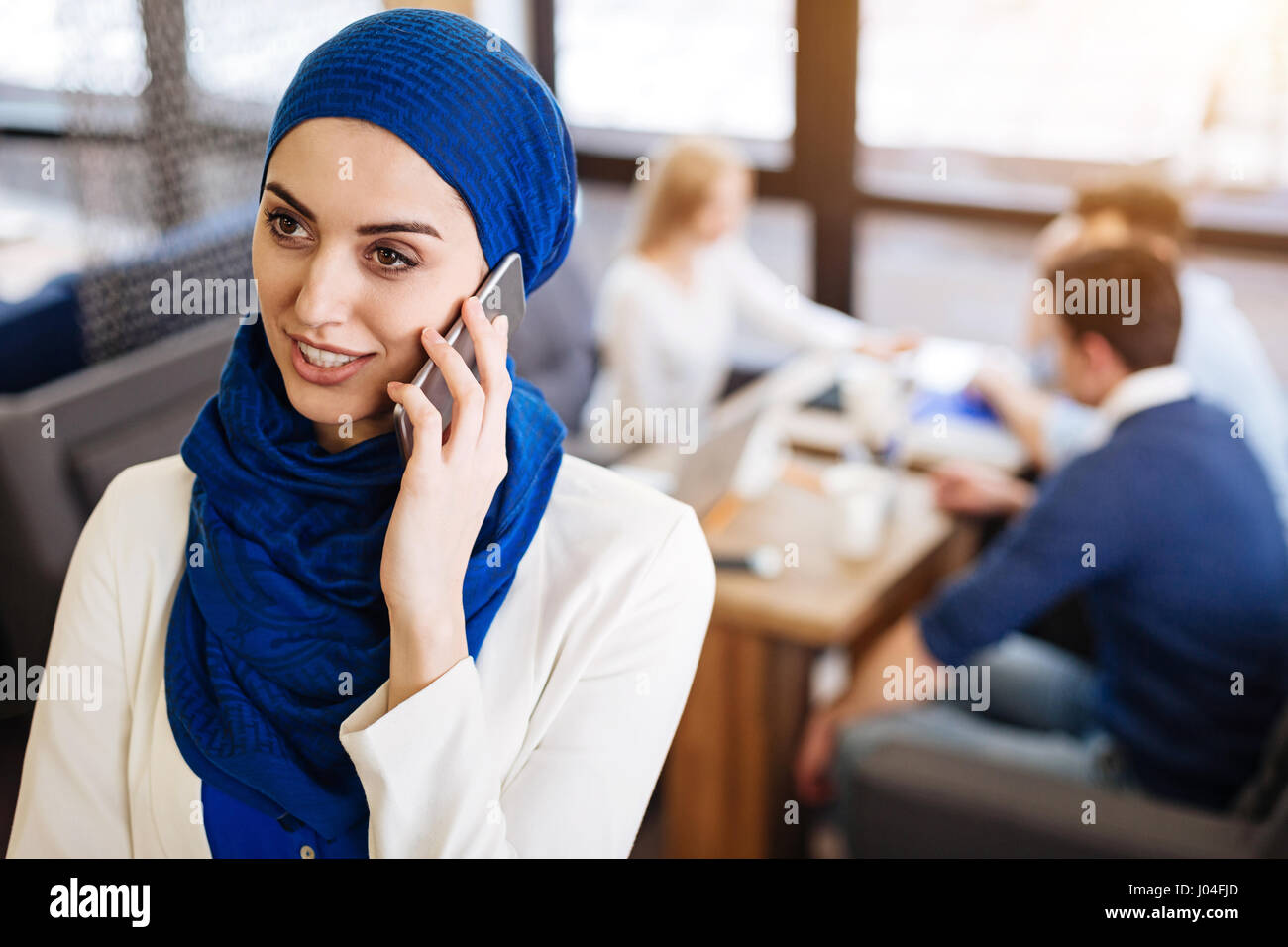 Pleasant muslim woman talking on smart phone Stock Photo - Alamy