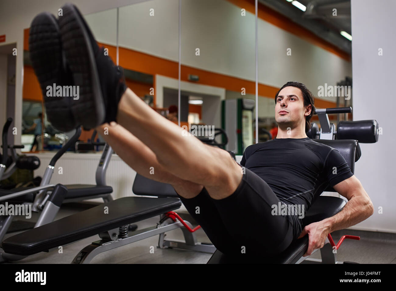 Full length portrait of muscular build man while doing legs press ...