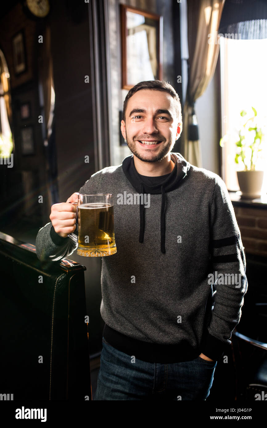 single man in a pub or bar holding the beer high in the air Stock Photo ...