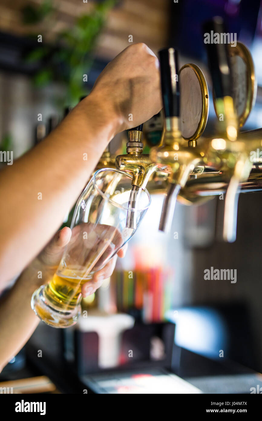 Mans hand pouring pint of beer behind the bar Stock Photo - Alamy