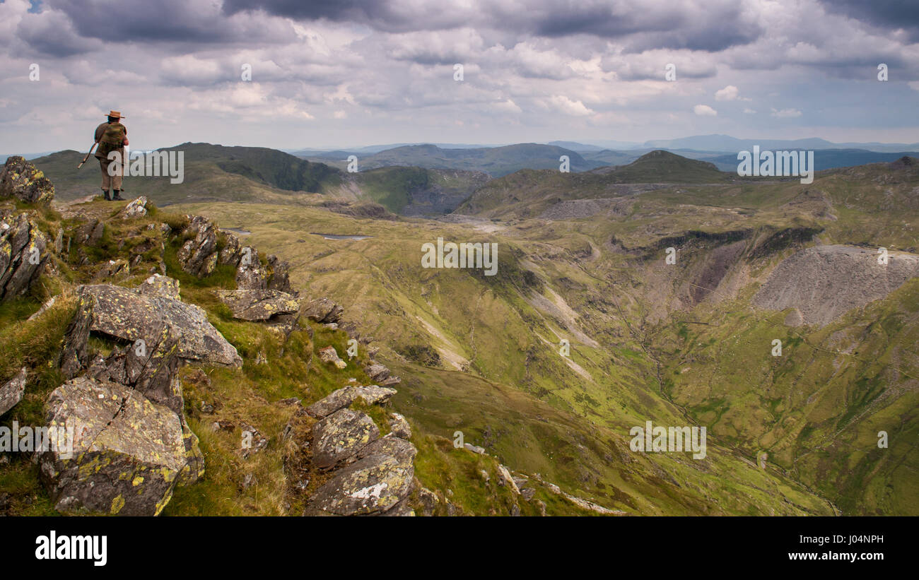 A hiker stands on the summit of Cnicht, a mountain in the Moelwyn ...