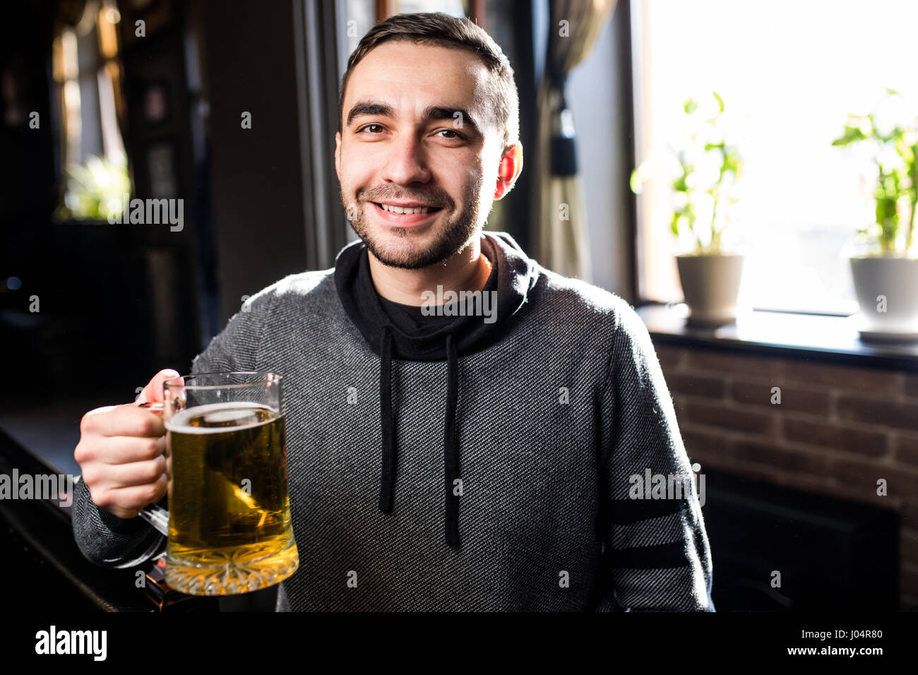single man in a pub or bar holding the beer high in the air Stock Photo ...