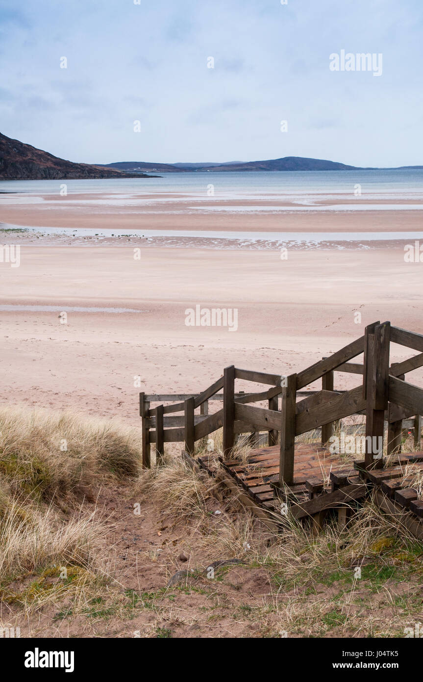 Wooden boardwalk steps cross sand dunes and lead down to the beach at ...