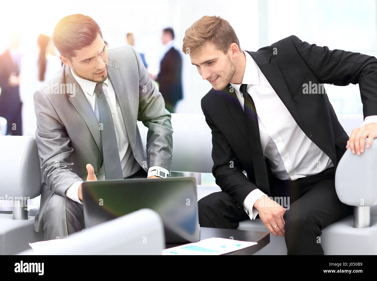 Smiling business men showing something on computer as colleague looking ...