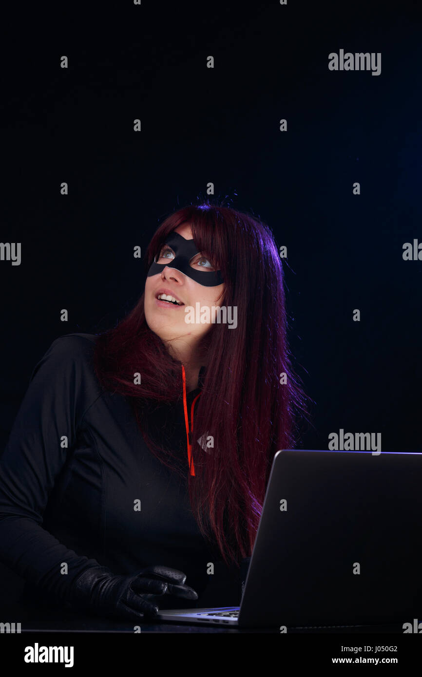 Smiling brunette bandit with laptop Stock Photo - Alamy