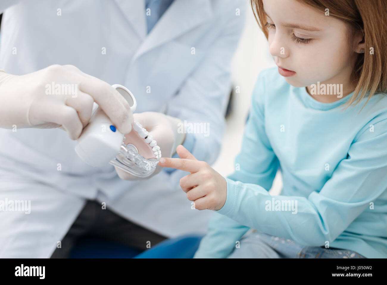 You can touch it. Professional friendly pediatric dentist giving his ...