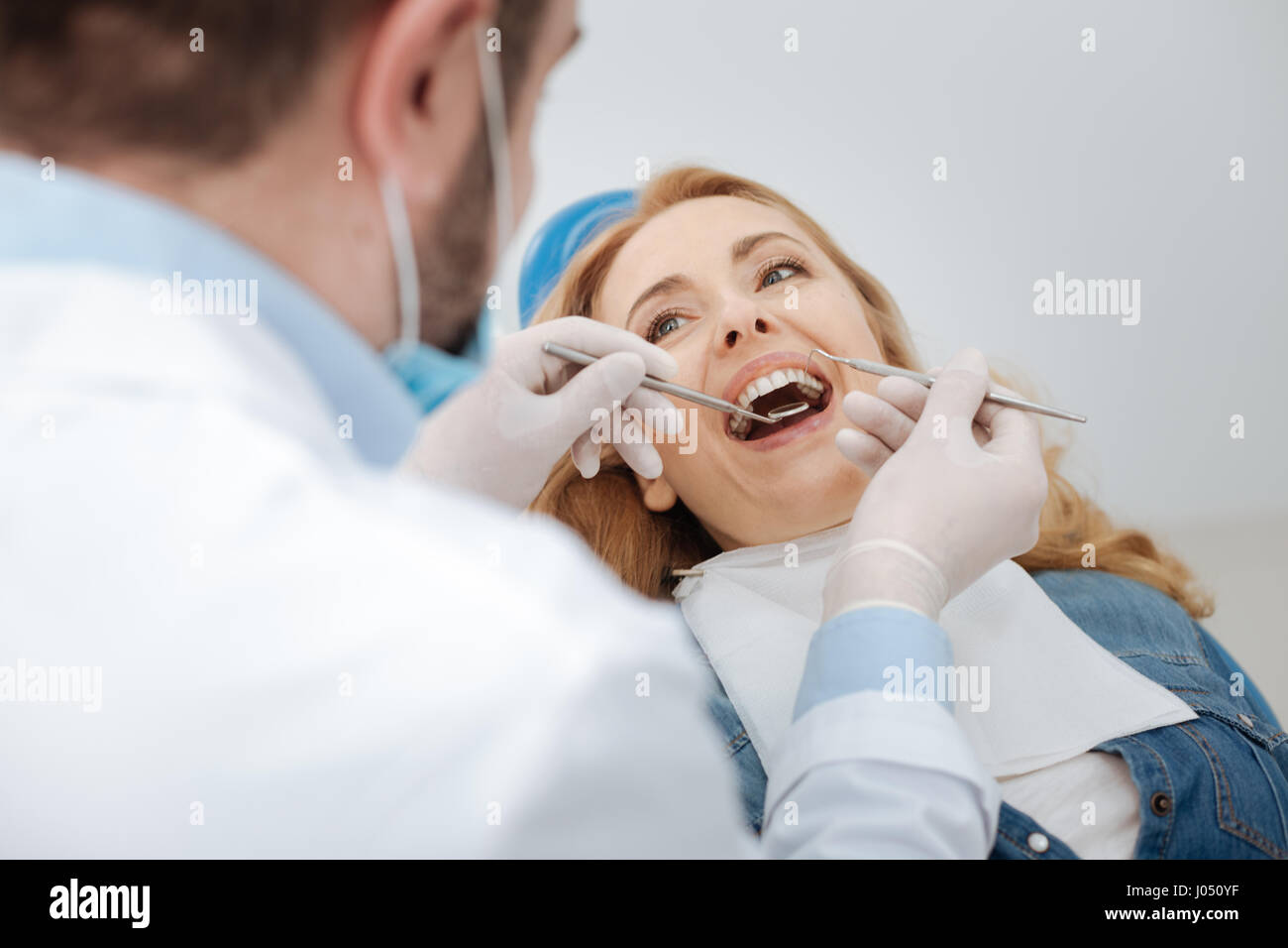 Optimistic beautiful lady getting her teeth checked Stock Photo - Alamy