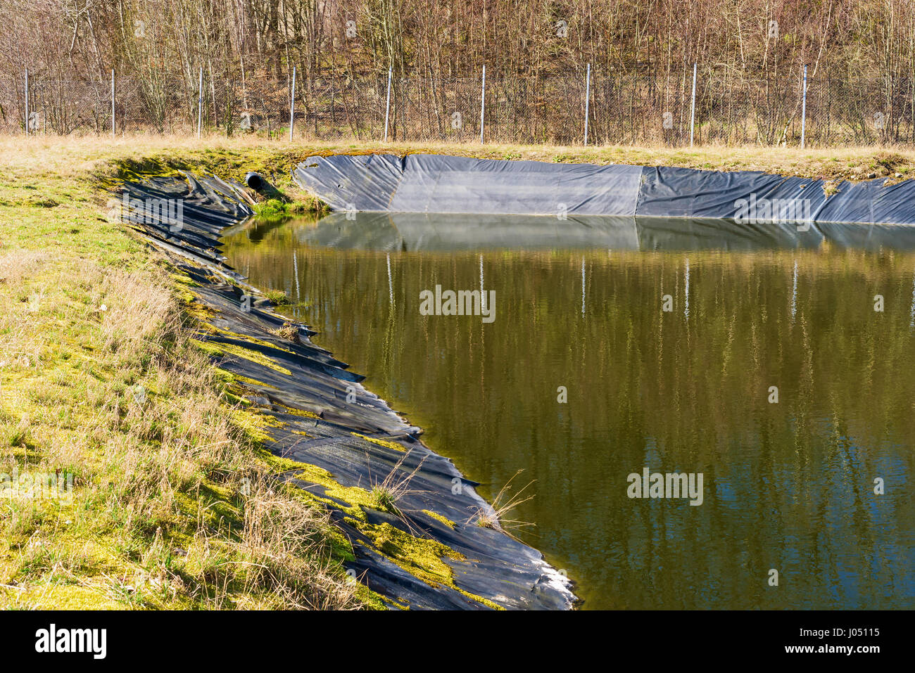 Landfill leachate pouring into pond from a black pipe. Location Ronneby ...