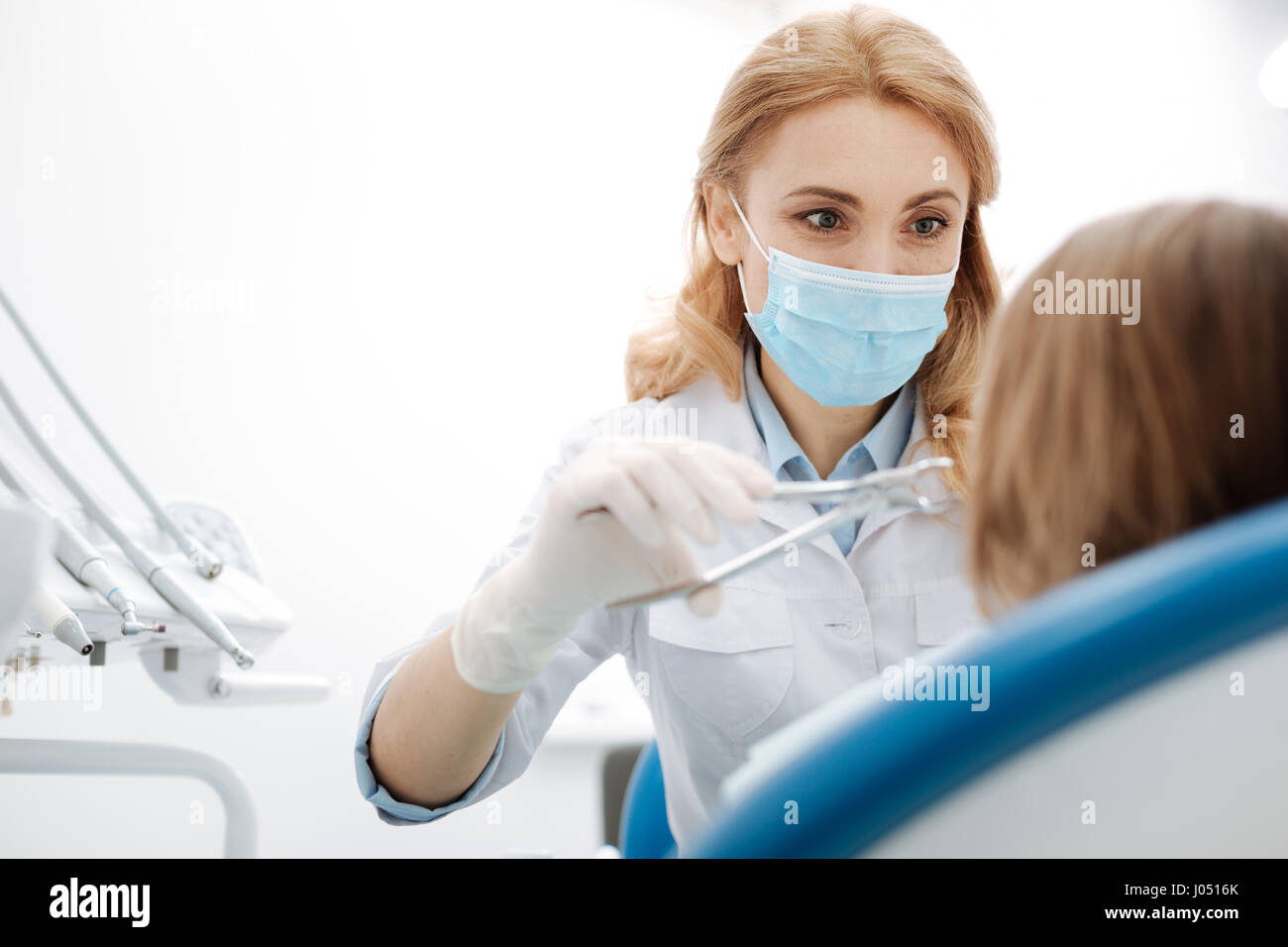 Professional young dentist conducting an operation Stock Photo - Alamy