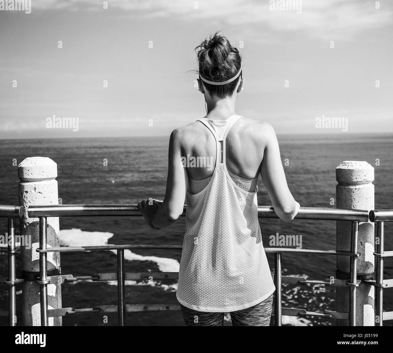 Look Good, Feel great! Seen from behind young woman in fitness outfit ...