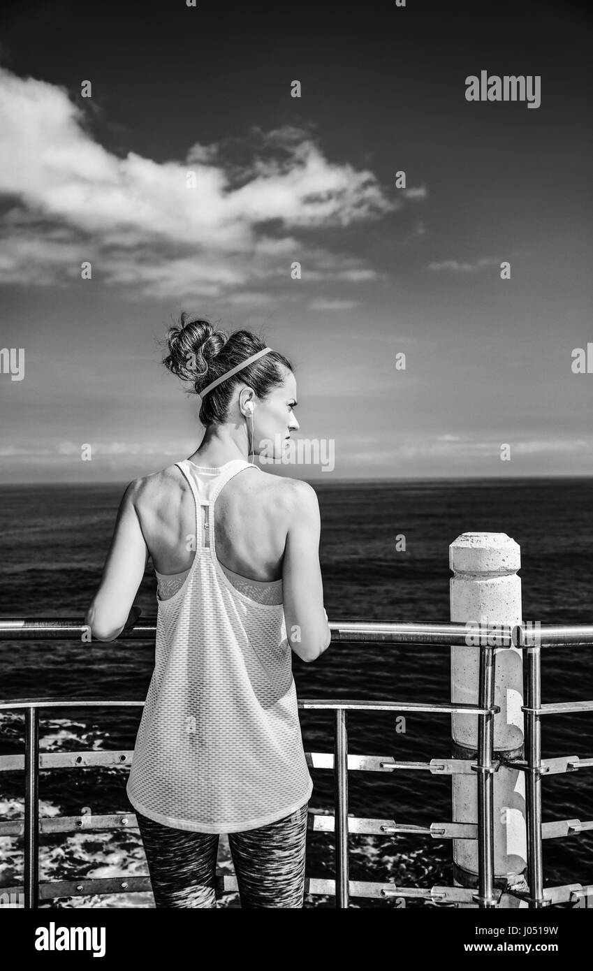 Look Good, Feel great! Seen from behind young woman in fitness outfit ...