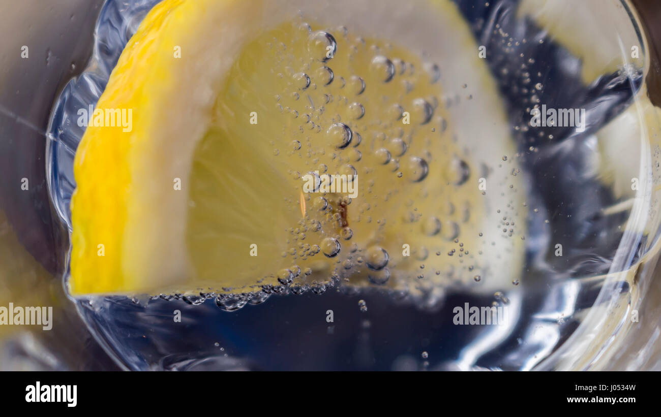 a slice of lemon dipped in sparkling water. close up Stock Photo - Alamy