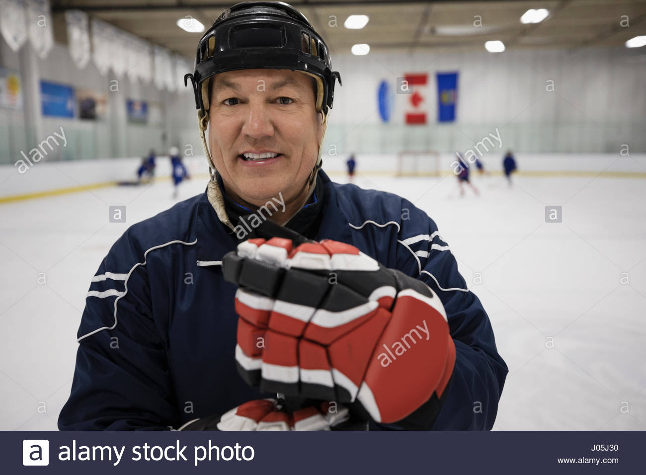 Portrait confident male ice hockey coach wearing helmet on ice hockey ...