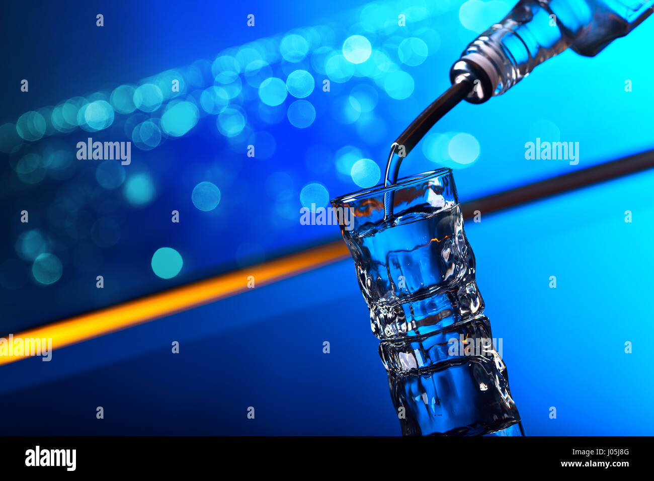 Glass of vodka in bar on a blue background Stock Photo - Alamy