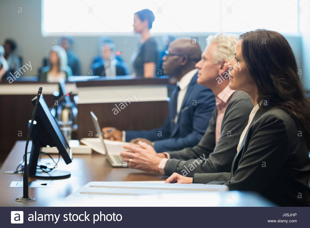 Attentive attorneys and defendant at table in legal trial courtroom ...