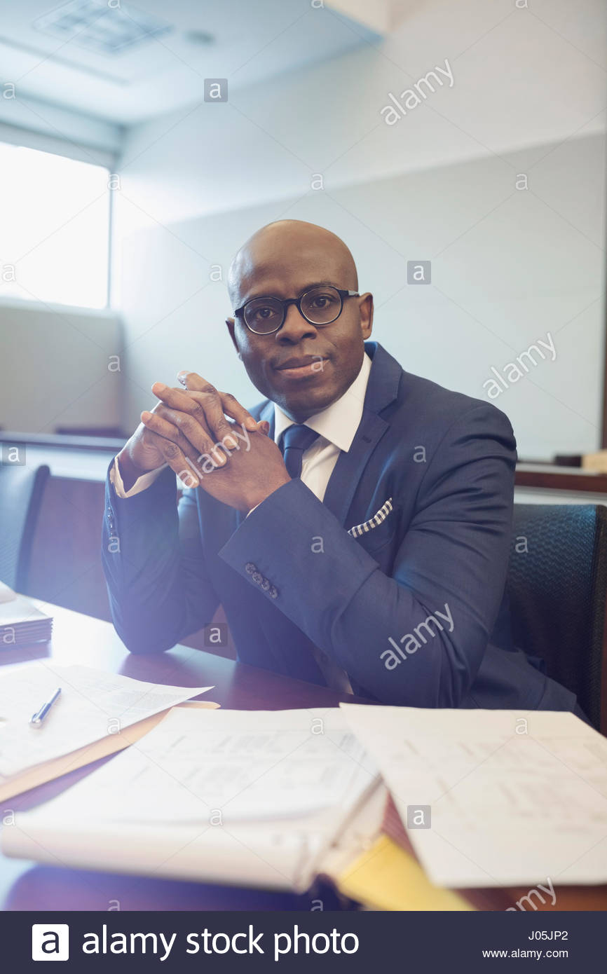 Portrait confident male prosecutor attorney with paperwork in courtroom ...