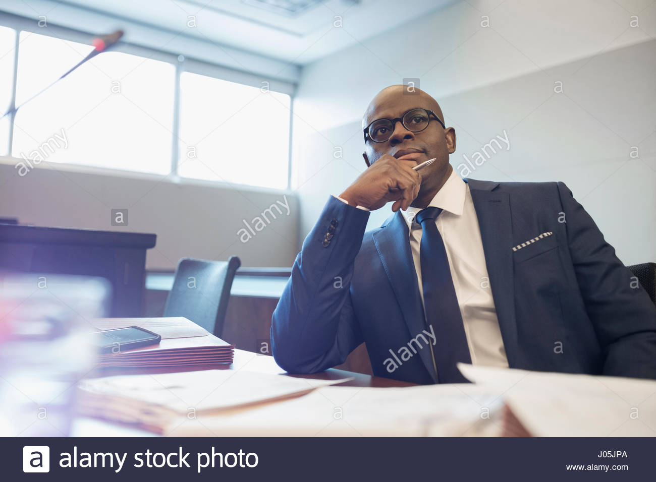 Serious, attentive male prosecutor attorney listening in courtroom ...