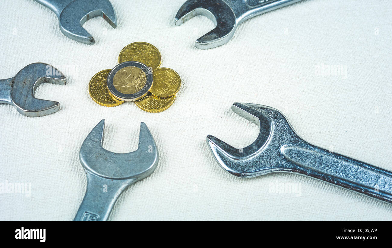 Euro coins and wrench tools as symbol of re-configuration european ...