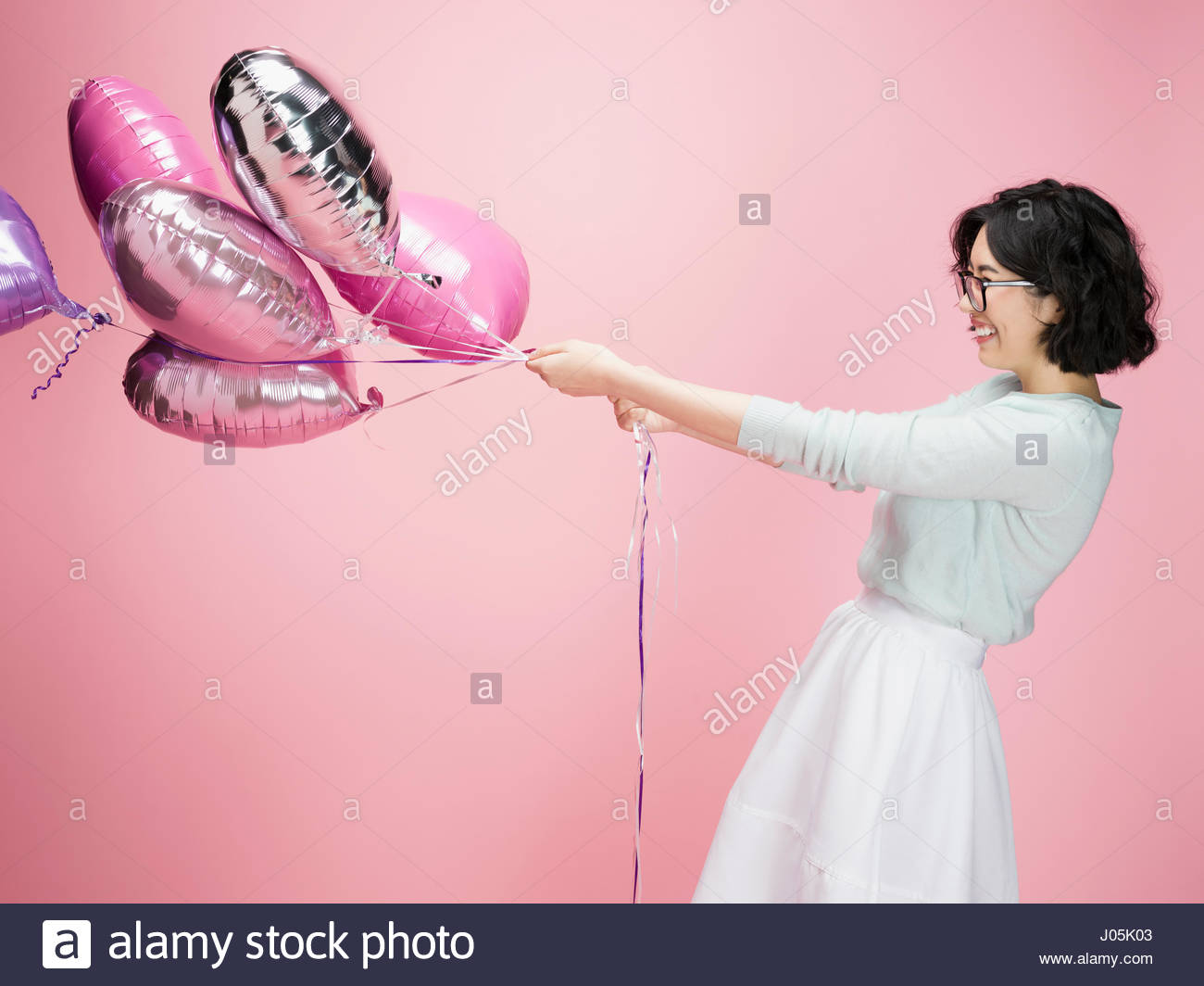 Woman holding heart pink balloons hi-res stock photography and images ...