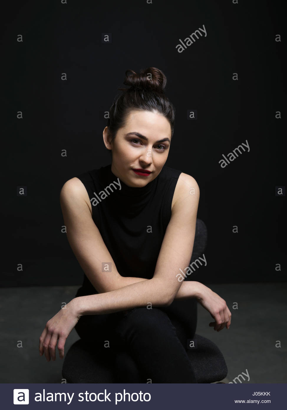 Portrait of a young woman leaning against chair hi-res stock ...
