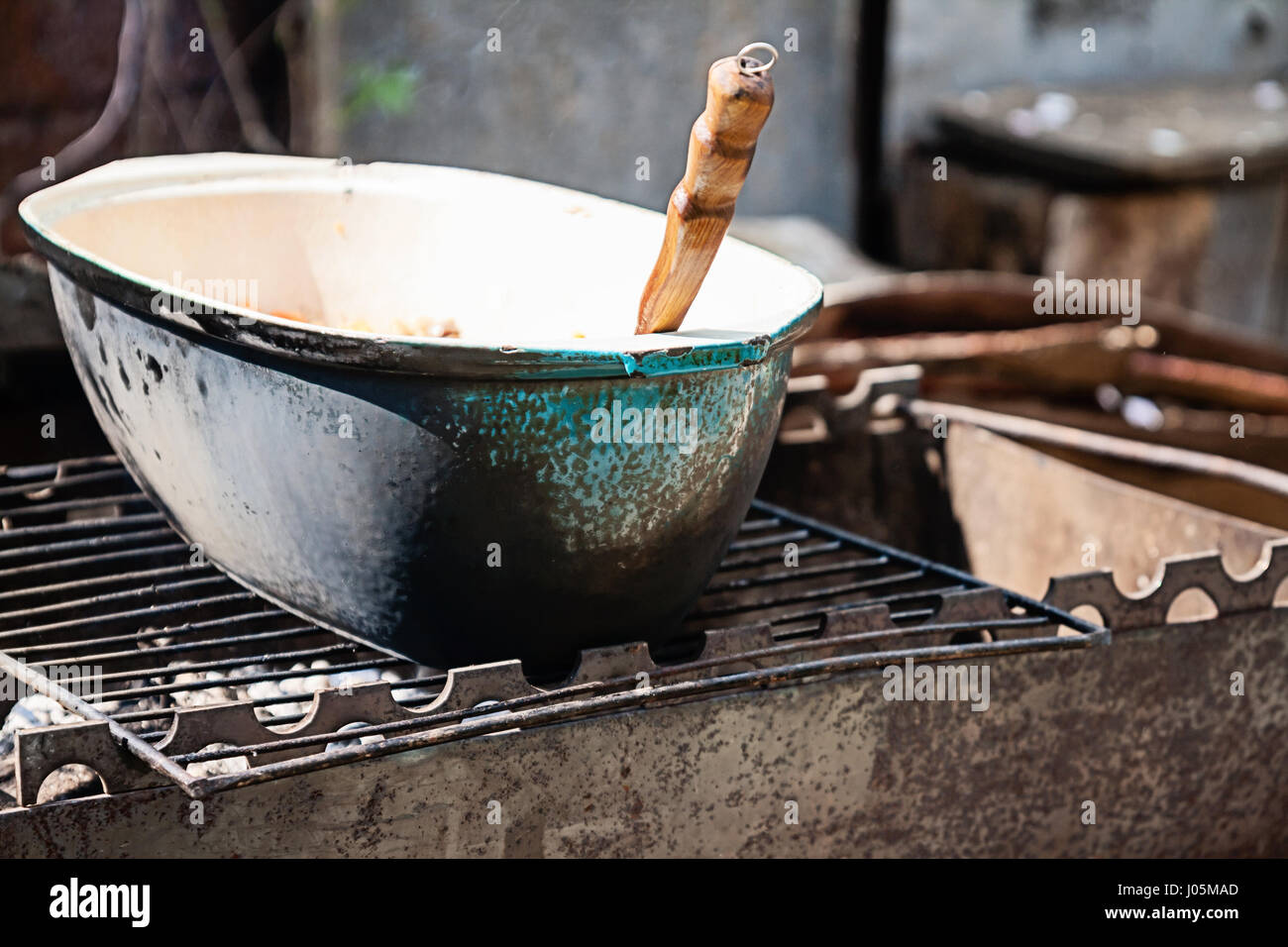 on the grill stands a cauldron in which to prepare meat and vegetables ...