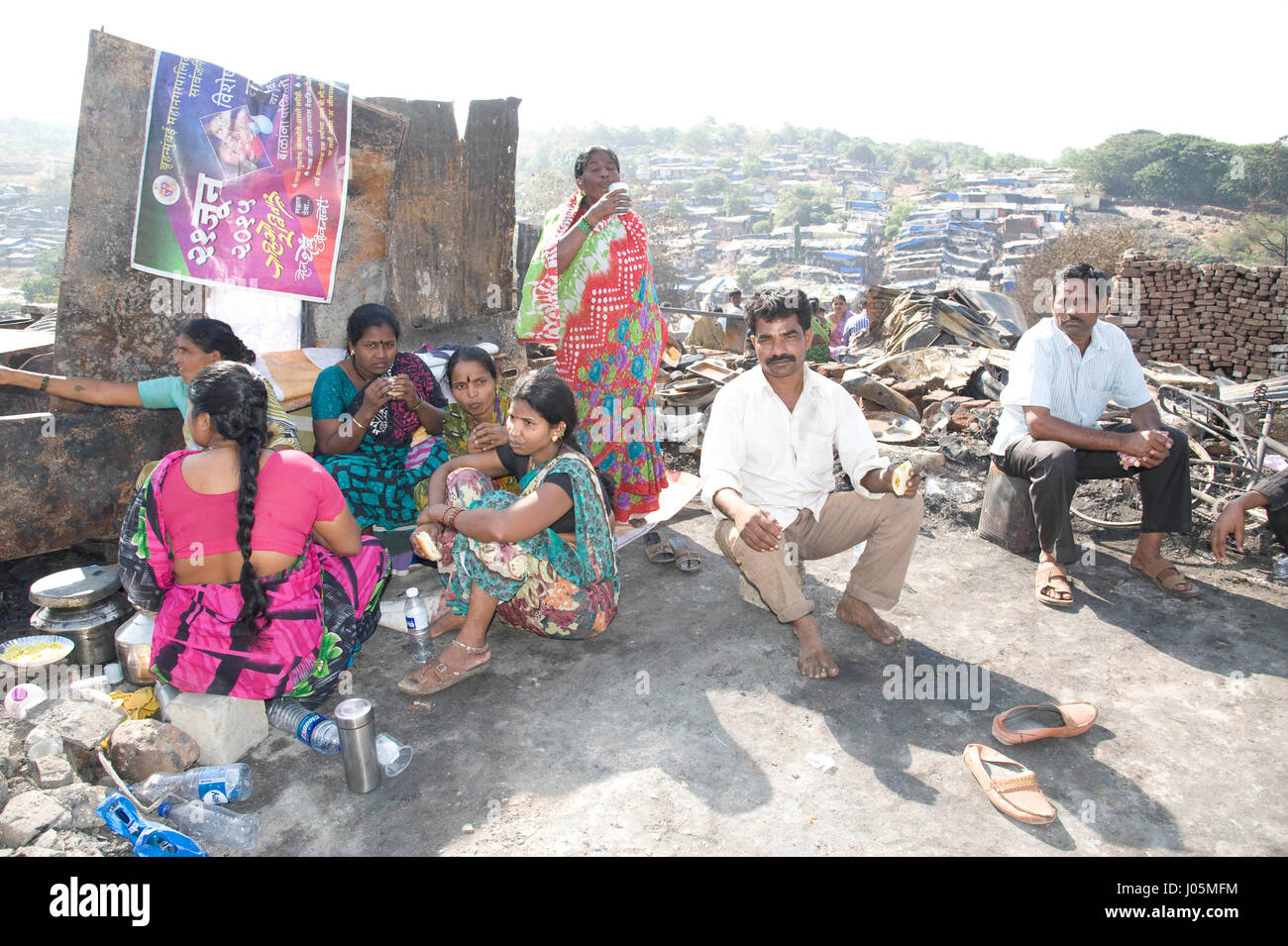 People sitting eating after slum fire, damu nagar, kandivali, mumbai ...
