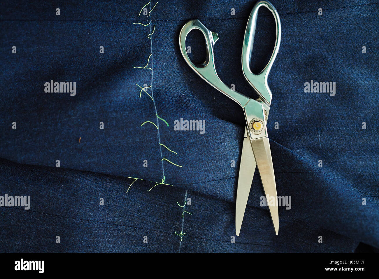 Scissors and piece of dark blue fabric Stock Photo - Alamy