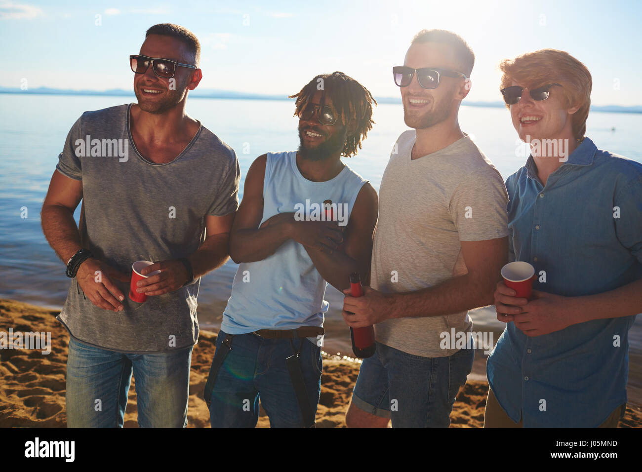 Multi-ethnic group of guys in sunglasses enjoying beach party Stock ...