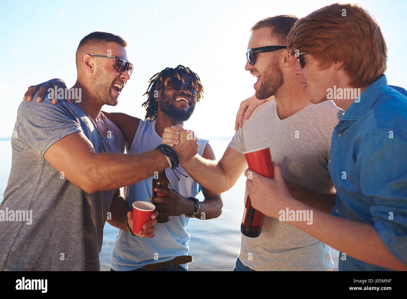 Friendly guys having fun on summer weekend by seaside Stock Photo - Alamy