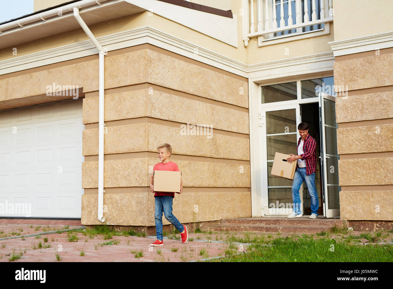 Little boy and his father with boxes leaving their house Stock Photo ...