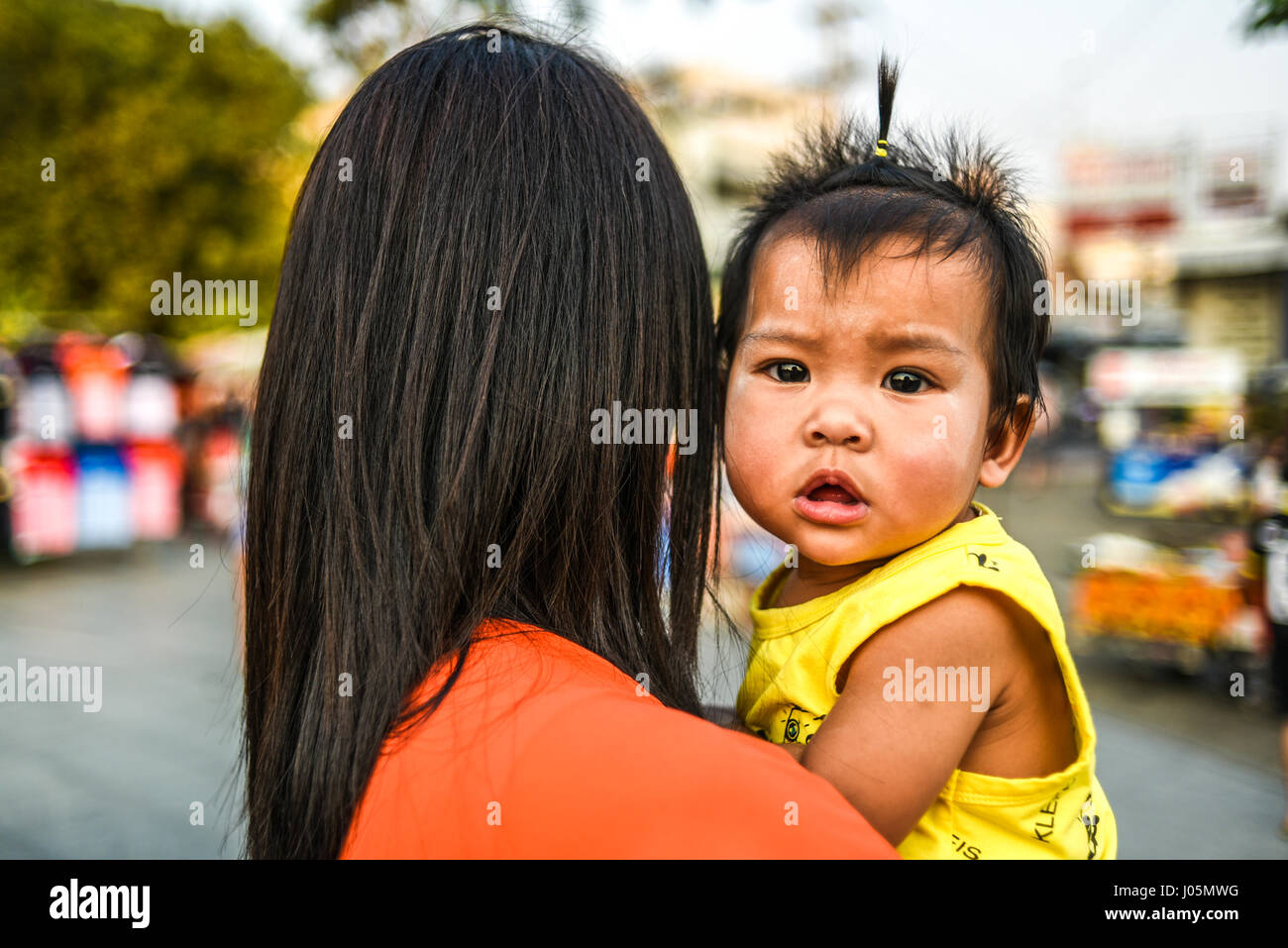 Kanchanaburi, Thailand, March 5, 2016: Little thai child on a mothers ...