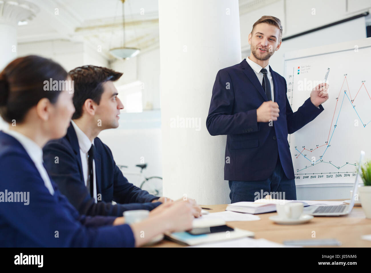 Young confident man pointing at whiteboard while explaining graph Stock ...