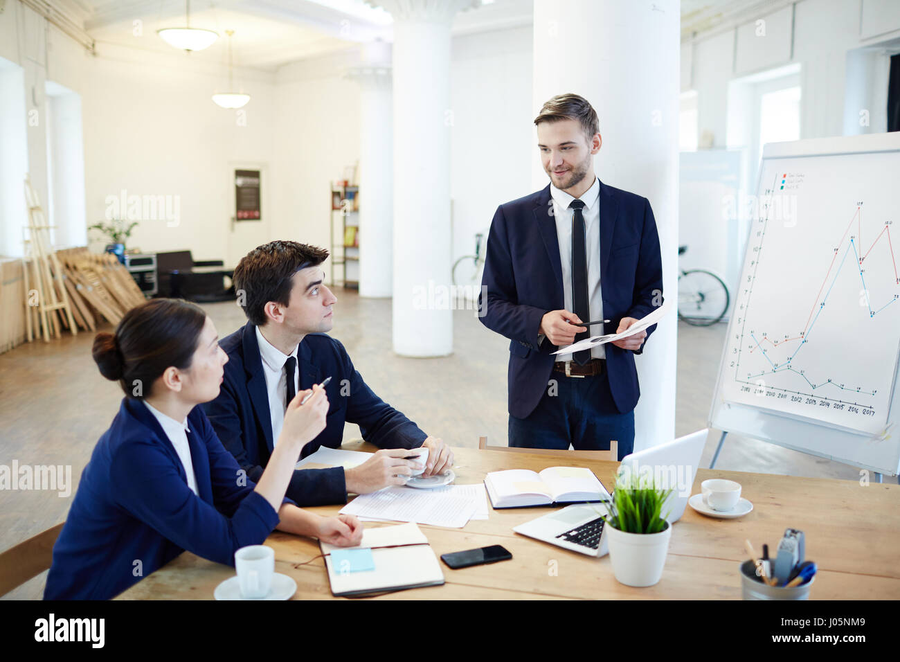 Business group discussing new strategies and listening to report of ...