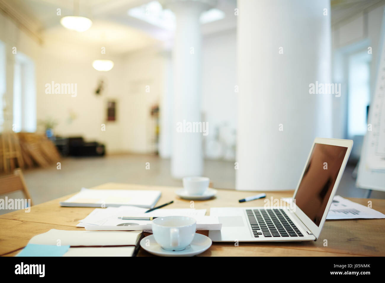 Open laptop, cup of tea and documents on table Stock Photo - Alamy