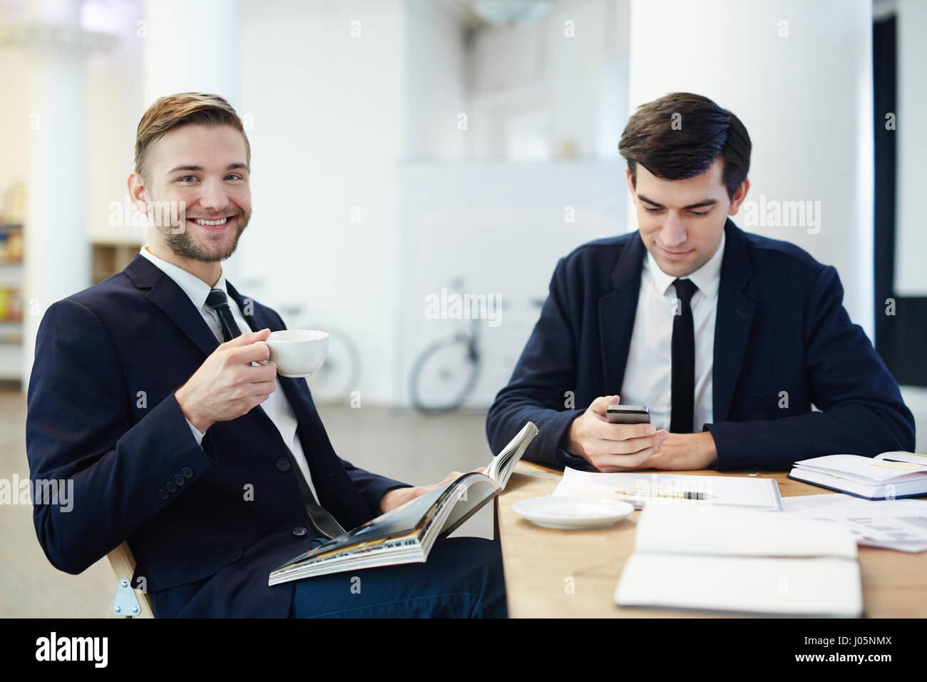 Smiling leader having tea at break Stock Photo - Alamy