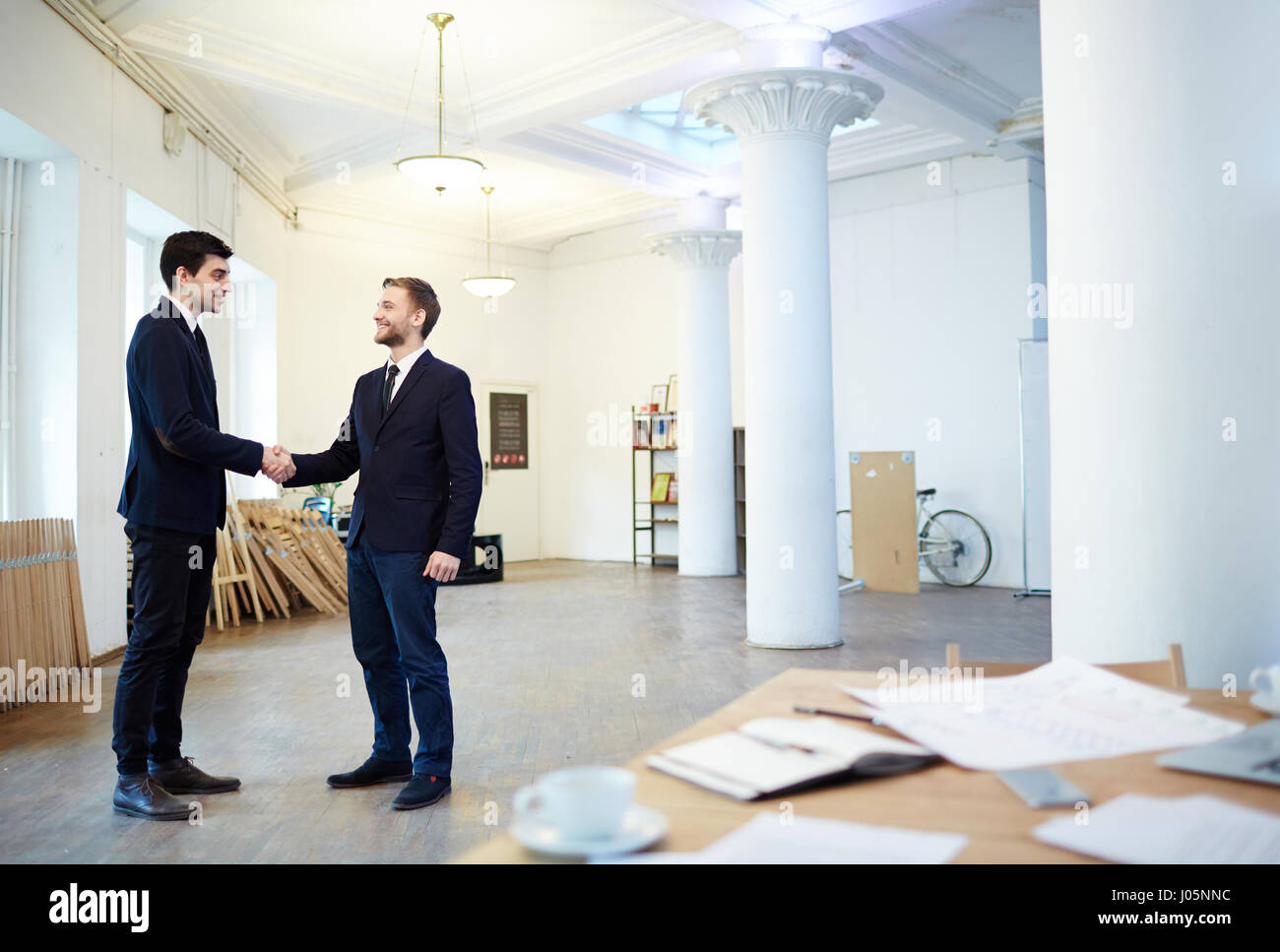 Young business partners greeting one another by handshake Stock Photo ...