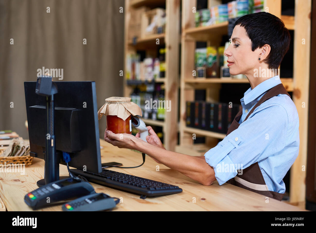 Shop assistant scanning jar with pickled vegs Stock Photo - Alamy