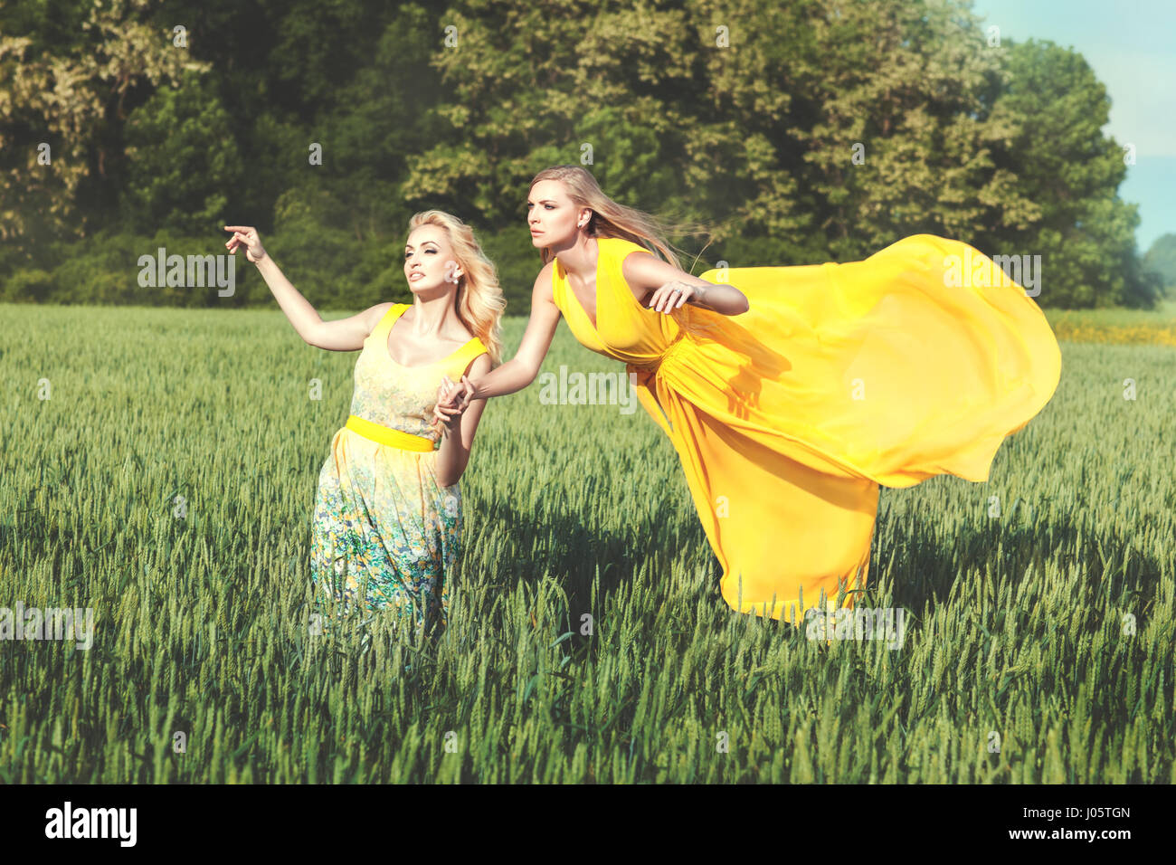 Woman walks across the field behind her levitating another woman Stock ...