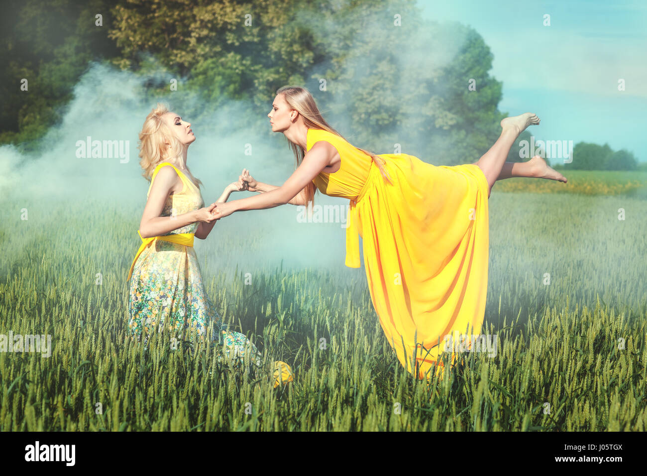 Two women hold each other's hands. One woman levitates over the field ...