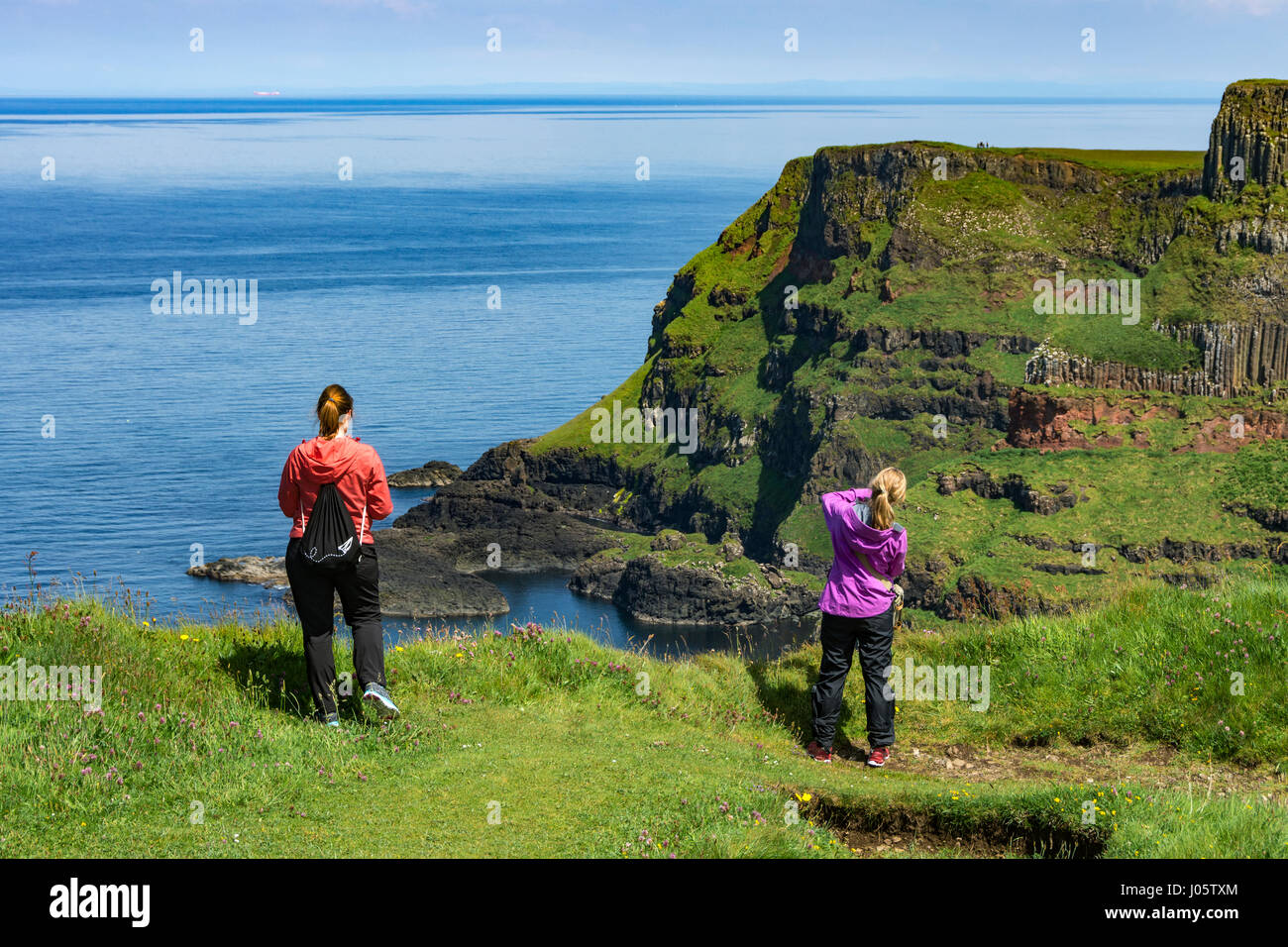 Walkers on the Causeway Coast footpath above Port na Plaeskin, County ...