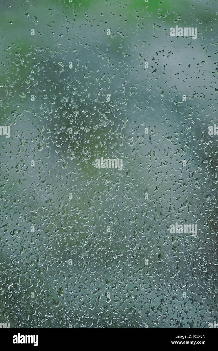 Rainy day, raindrops on wet window glass, vertical bright abstract rain ...