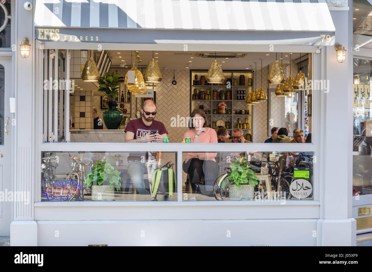 A couple sit in the open window of the Efes Express restaurant on Brick ...