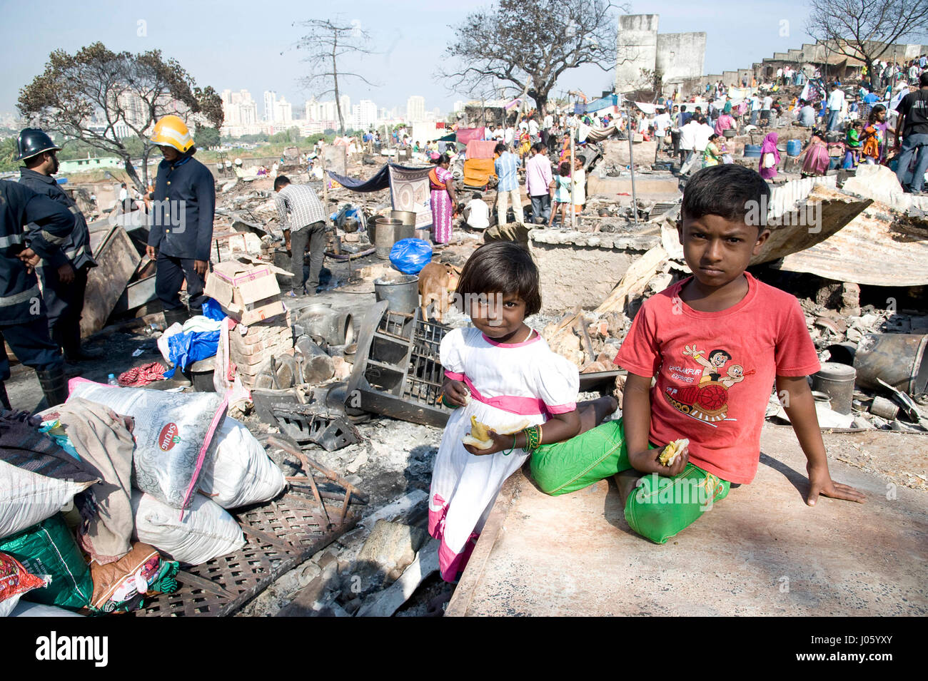 Children sitting eating after slum fire, damu nagar, kandivali, mumbai ...