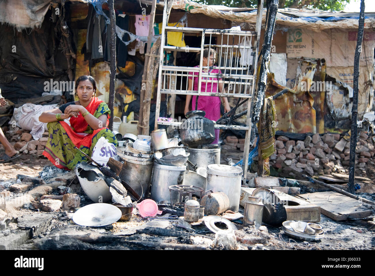 Woman sitting with utensils after slum fire, damu nagar, kandivali ...