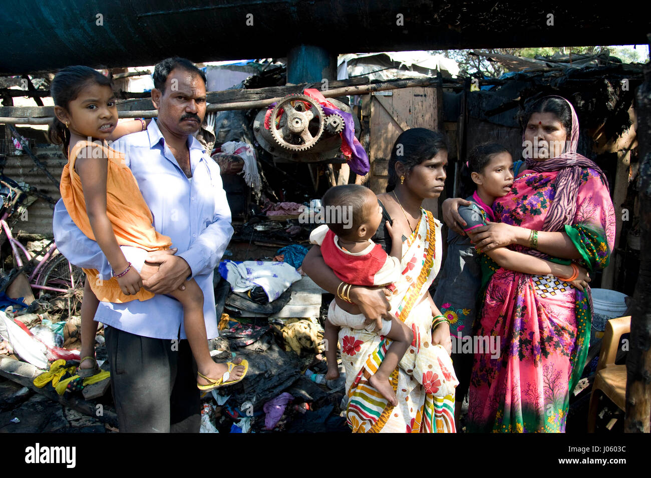 Family standing after slum fire, damu nagar, kandivali, mumbai ...