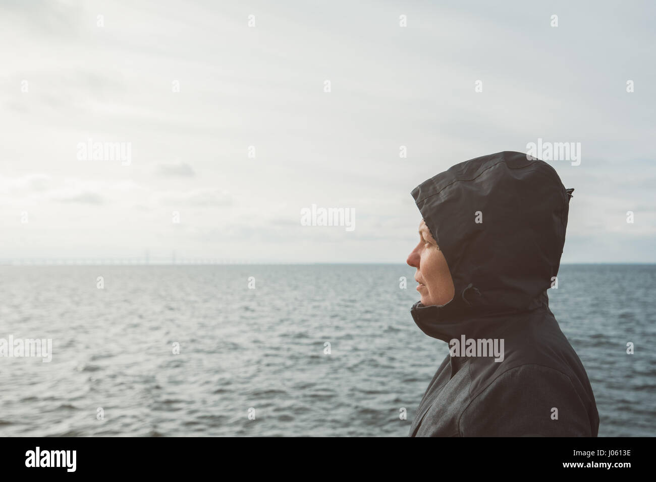 Optimistic female person enjoying morning sunlight at sea coastline on ...